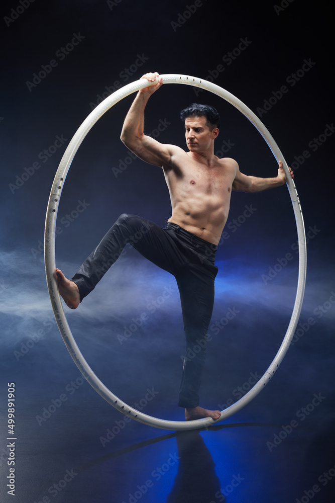Circus performer artist with muscles body in a Cyr Wheel (Roy Cyr ...