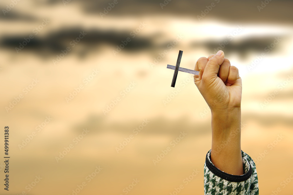 cross in the human hand on the light background of the sun Stock Photo ...