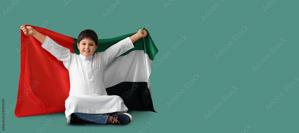 Cute little boy with national flag of UAE on green background with ...