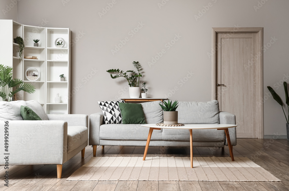 Interior of light living room with coffee table, sofas and houseplants ...