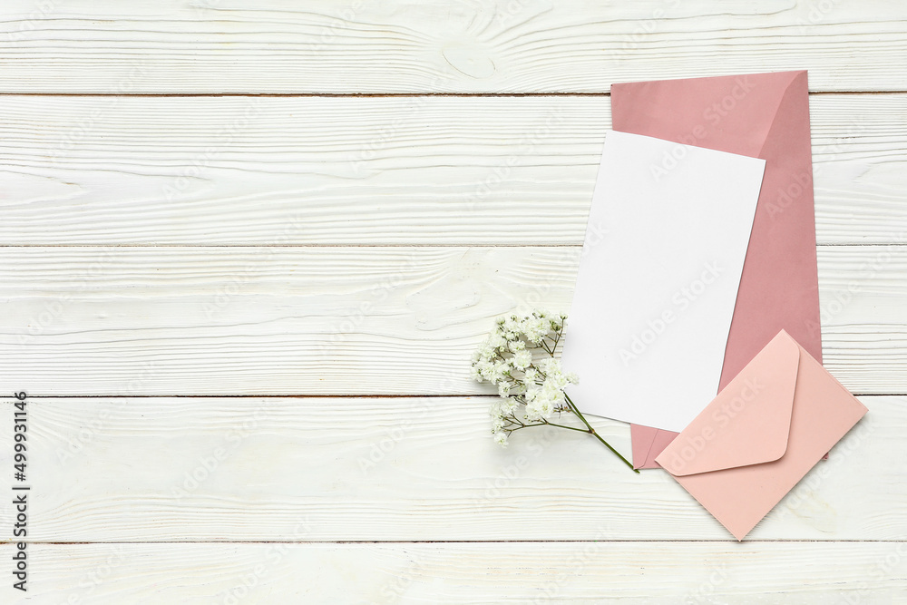 Envelopes with blank card and flowers on white wooden background Stock ...