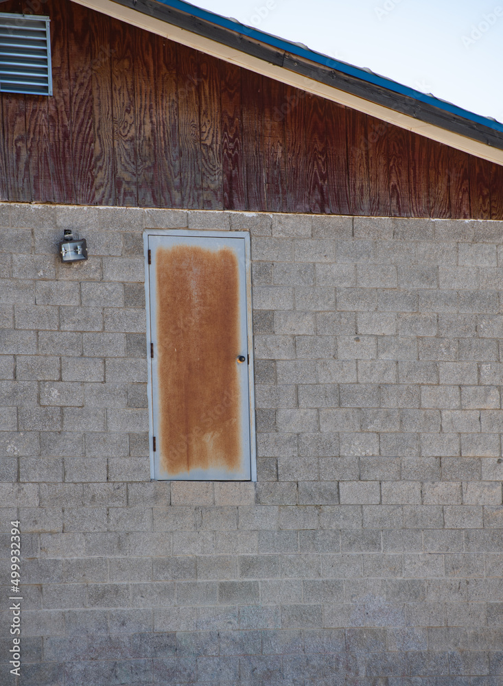 wooden door to nowhere in grey concrete block exterior wall of building ...