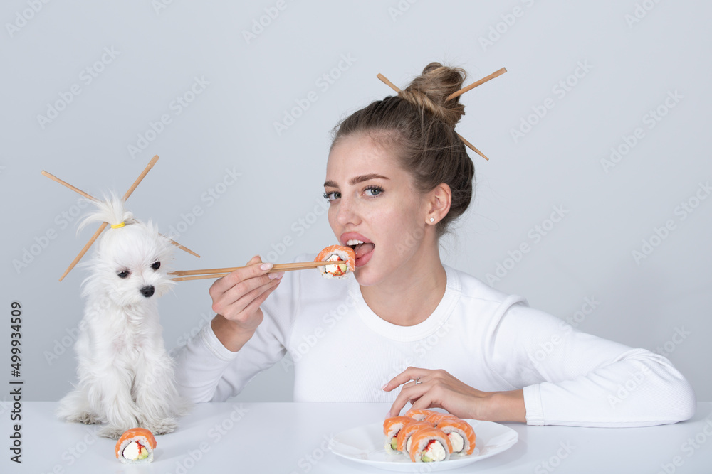 Sexy woman eat japanese traditional food sushi rolls. Girl is holding ...