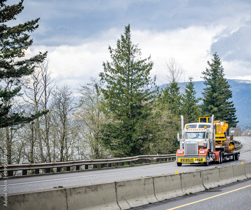 Orange classic big rig semi truck tractor with oversize load sign on ...