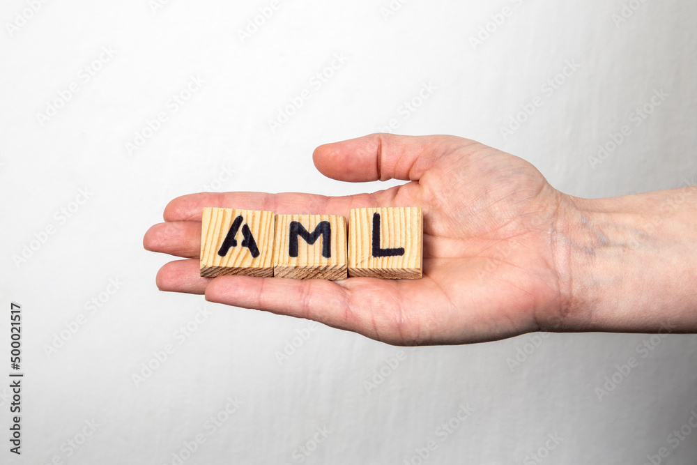AML Anti Money Laundering. Wooden alphabet letters in a woman's hand ...