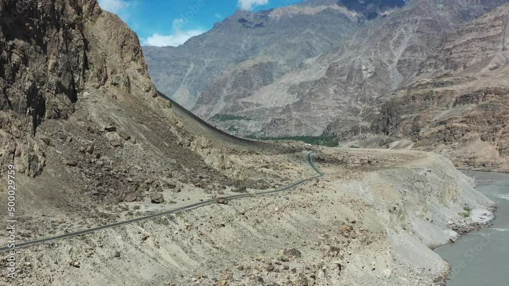 aerial drone flying up over the Indus River Valley as the river flows ...