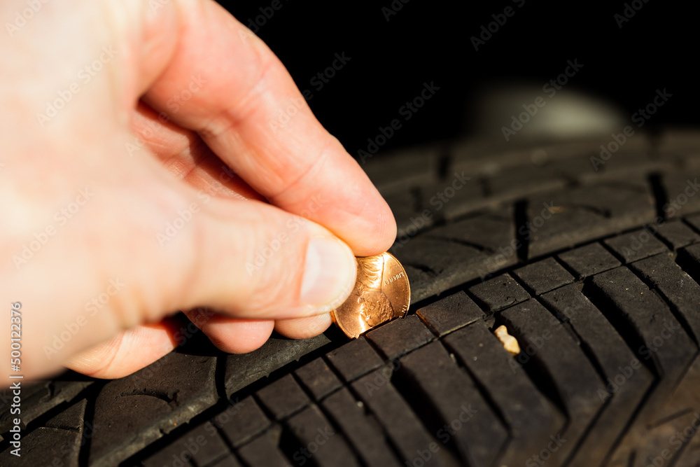 Checking tread depth on a tire by using a penny Stock Photo | Adobe Stock