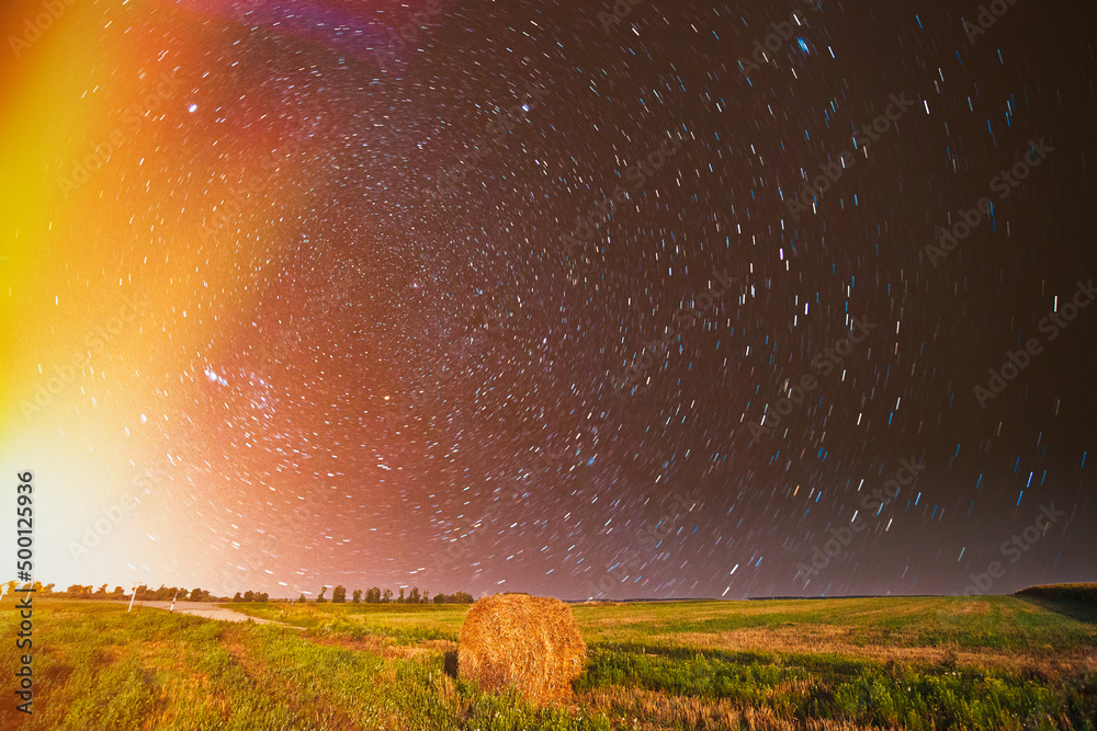 Night Starry Sky in rotation Above Country Field Meadow With Hay Bale ...