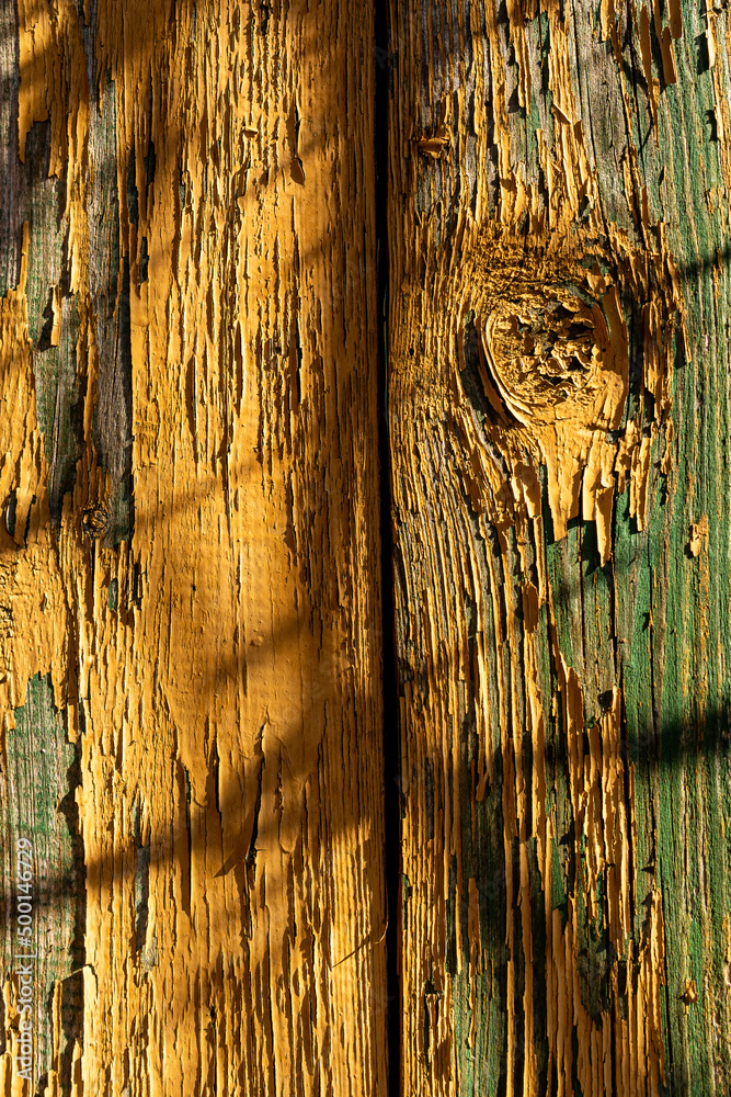 Yellow wodden planks covered with old flaking paint and visible wood ...