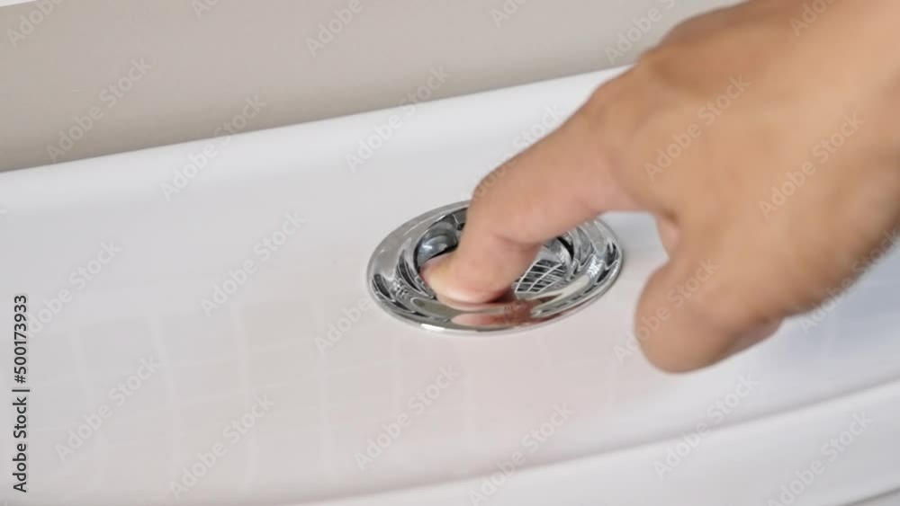 close-up of pressing pushing a button on the toilet with his finger To ...