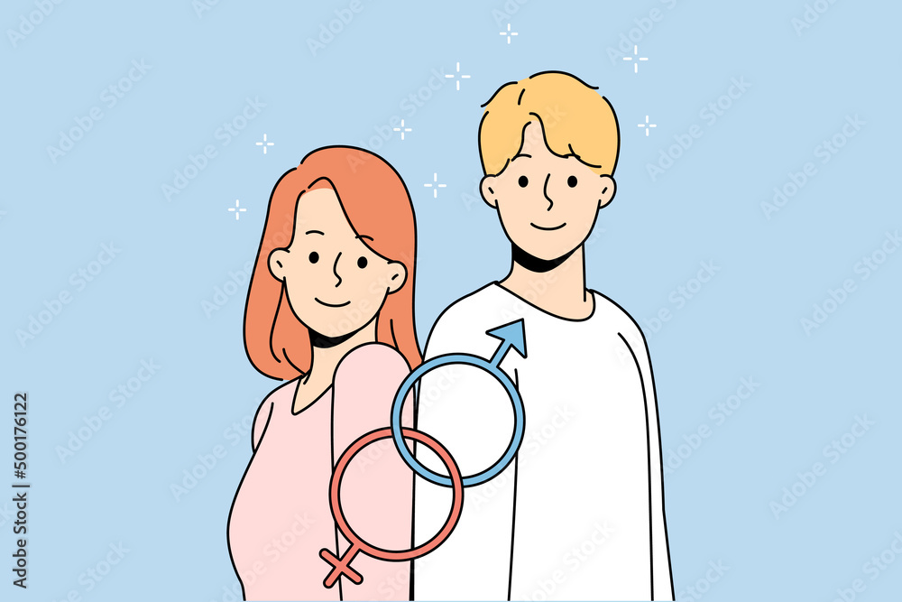 Portrait of smiling young man and woman with gender identity signs ...