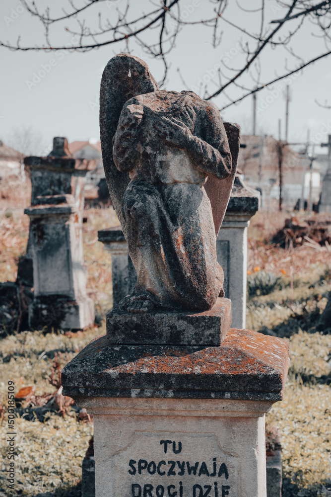 Damaged gravestone, beheaded stone angel sculpture at abandoned ancient ...