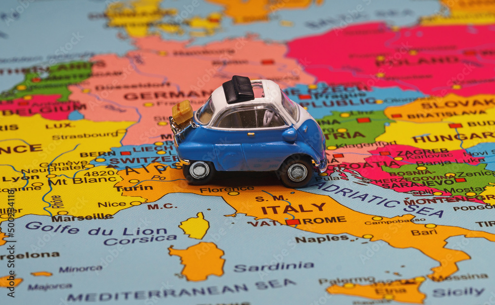 Small toy retro car in the middle of Europe map. Travel by car concept ...