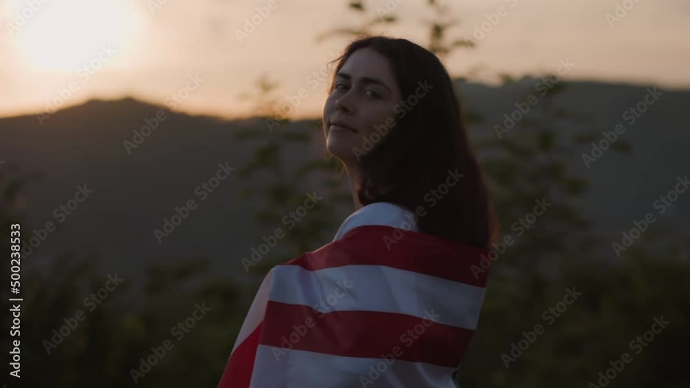 Independence Day. A young woman with an American flag draped over her ...