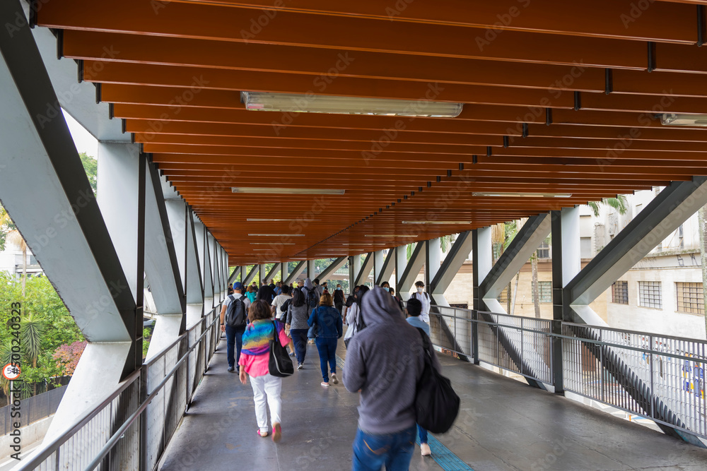 Passengers walking on the walkway of the Bandeira bus terminal ...