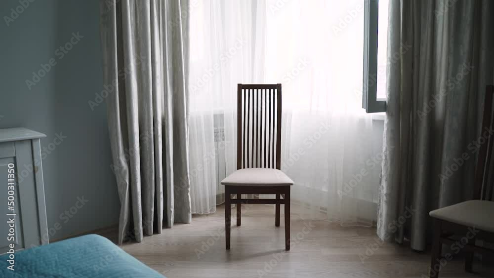 Wooden chair with slatted back stands in corner of cozy room near ...