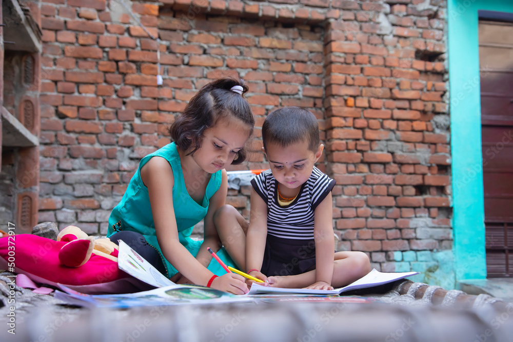 Portrait of little children studying on cot in the backyard Stock Photo ...