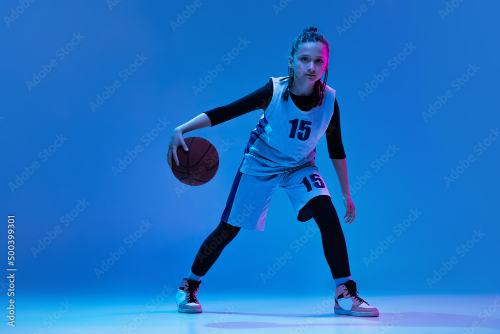 Portrait of teen girl, basketball player in motion, dribbling ball ...