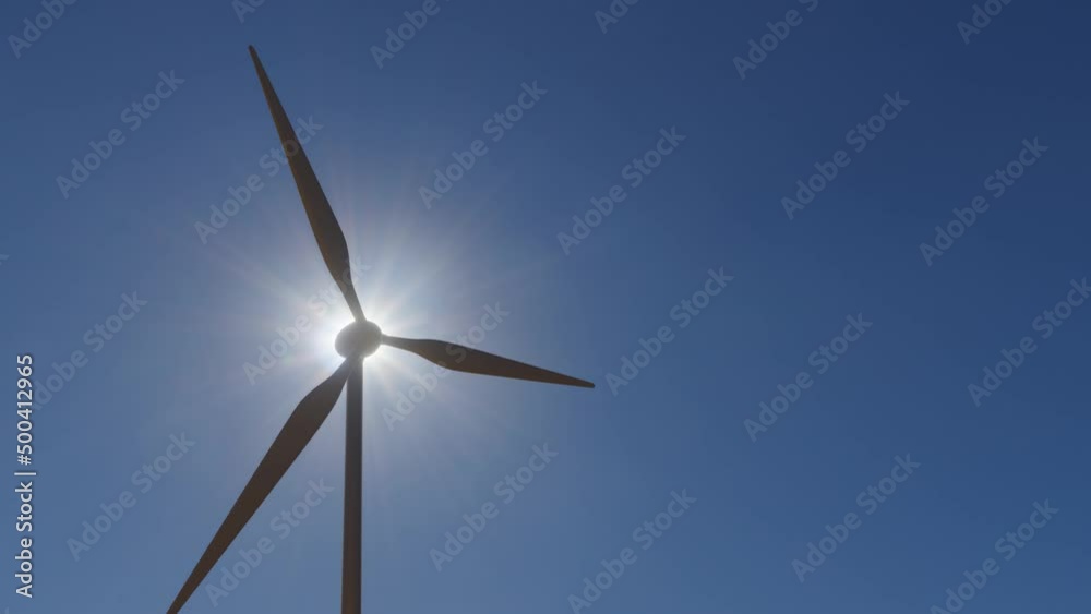 Loop of windturbine with bright sun behind turbine. Loop of 3D ...