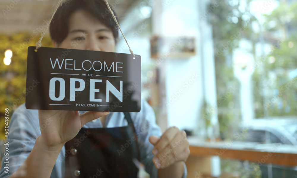 Business owner asian woman turning Welcome We're Open sign on fronton ...