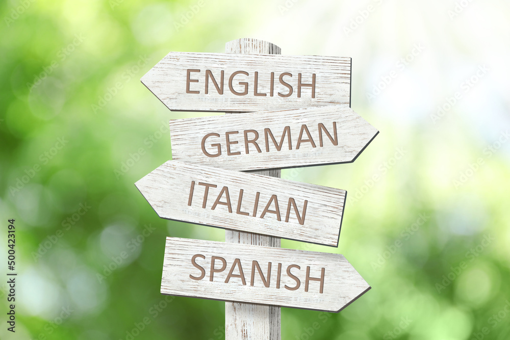 Wooden signpost with names of different languages outdoors Stock Photo ...