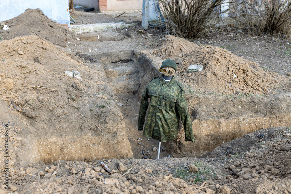 A scarecrow of a soldier in a green military russian uniform in a ...