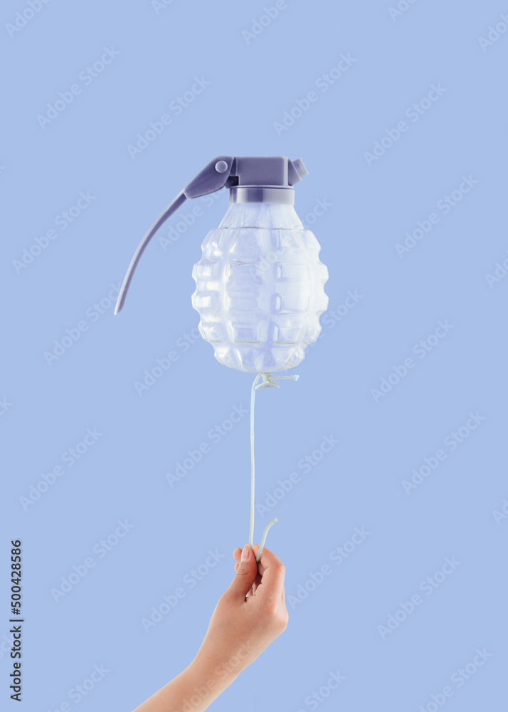 Child’s hand holds a rope with a tied balloon in the shape of a bomb on ...
