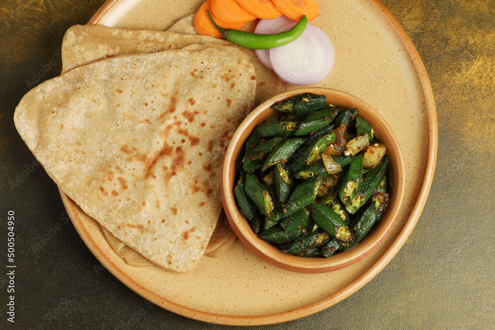 Bhindi masala or ladies finger fry served with indian roti chapati or ...