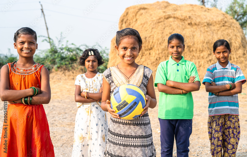 group of Indian village girls with one child holding football by ...