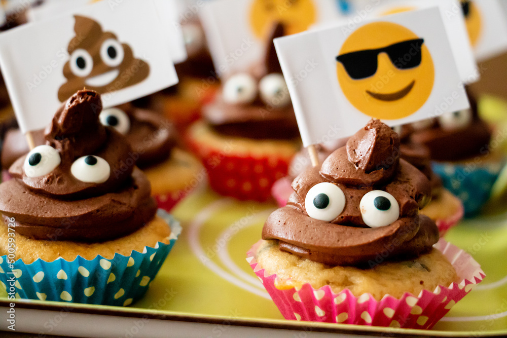 "Pile of poo" emoji cupcakes. Each with a flag of another emoji. Stock ...