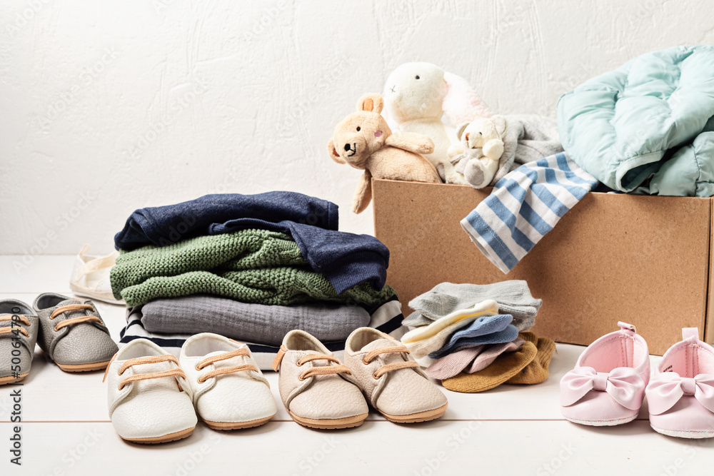 Baby and child clothes, toys in box. Second hand apparel idea. Circular ...