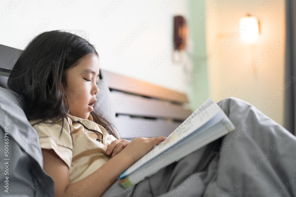 asian child student or kid girl reading book by sitting leaning pillow ...