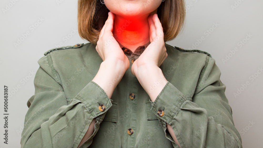 Female checking thyroid gland by herself. Close up of woman touching ...
