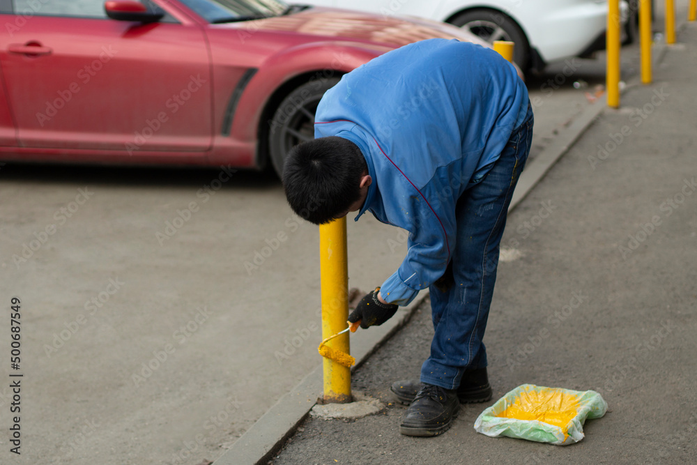 Painting a metal post with yellow paint. Parking bollard painting ...