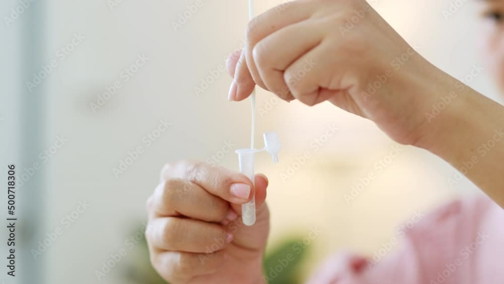 Close up hand using rapid antigen test kit (ATK) for self test at home ...