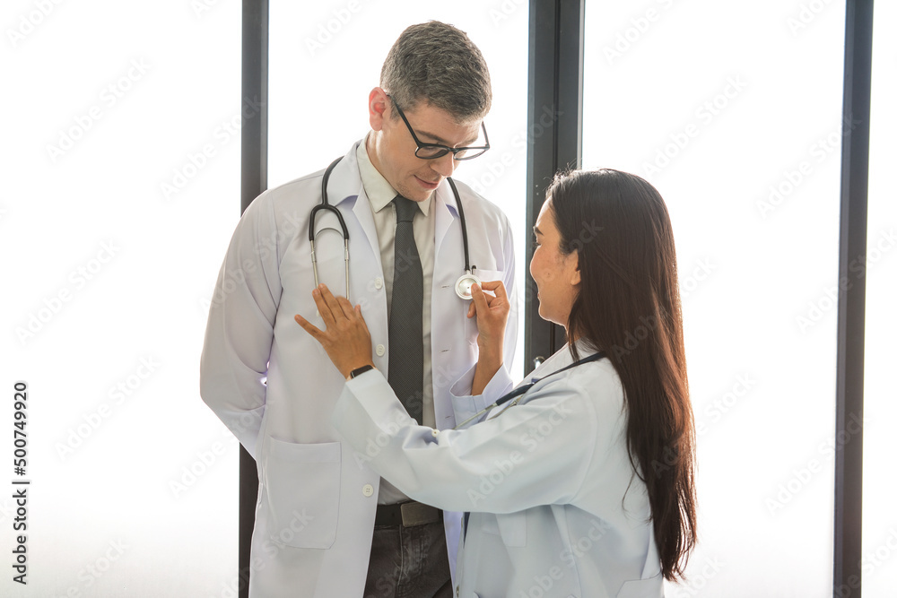 Asian female doctor couple arranges a ground coat for the young doctor ...
