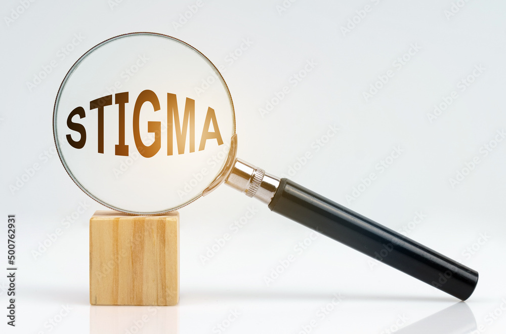 On a white surface there is a cube and a magnifying glass inside which ...