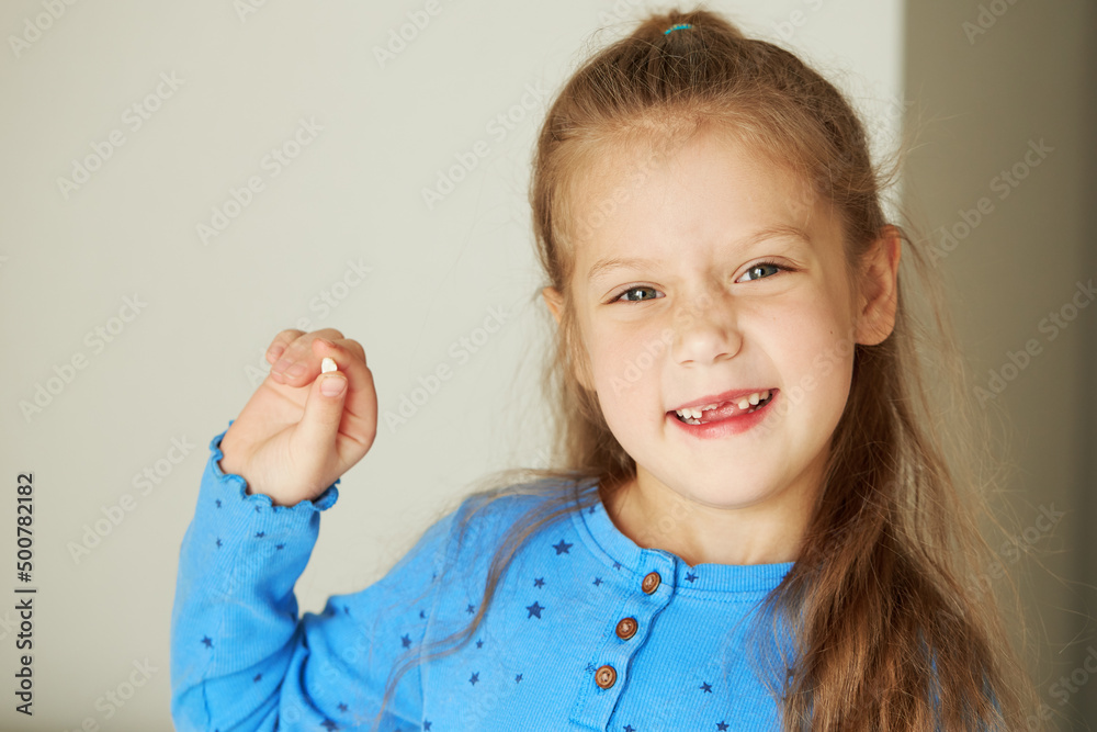 Toothless child. Cute little girl smiles broadly. The first milk tooth ...