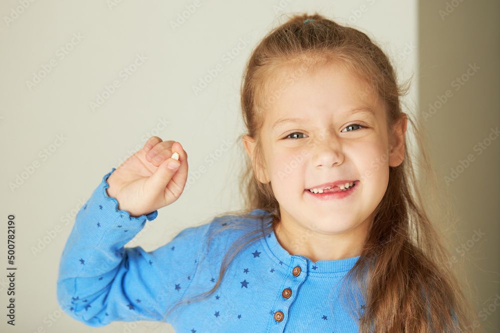 Toothless child. Cute little girl smiles broadly. The first milk tooth ...
