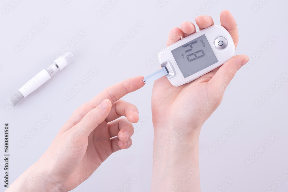Human using a glucometer to measure and test blood glucose levels from ...