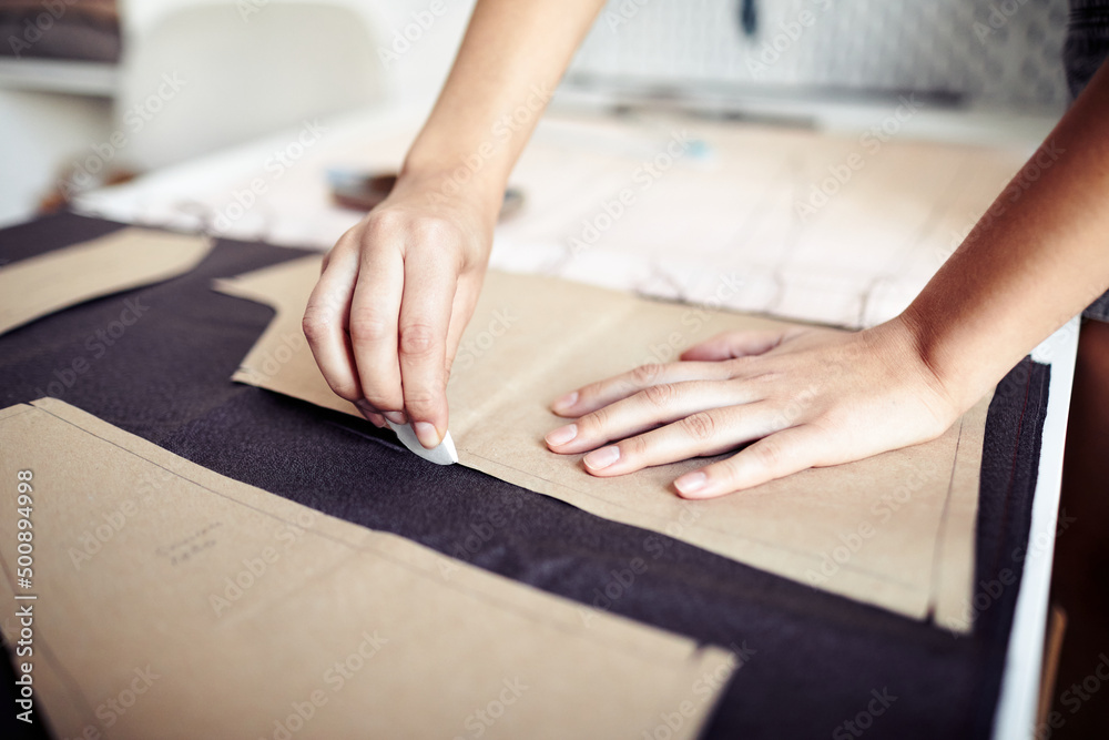 Hands of seamstress using chalk to outline cardboard sewing pattern on ...