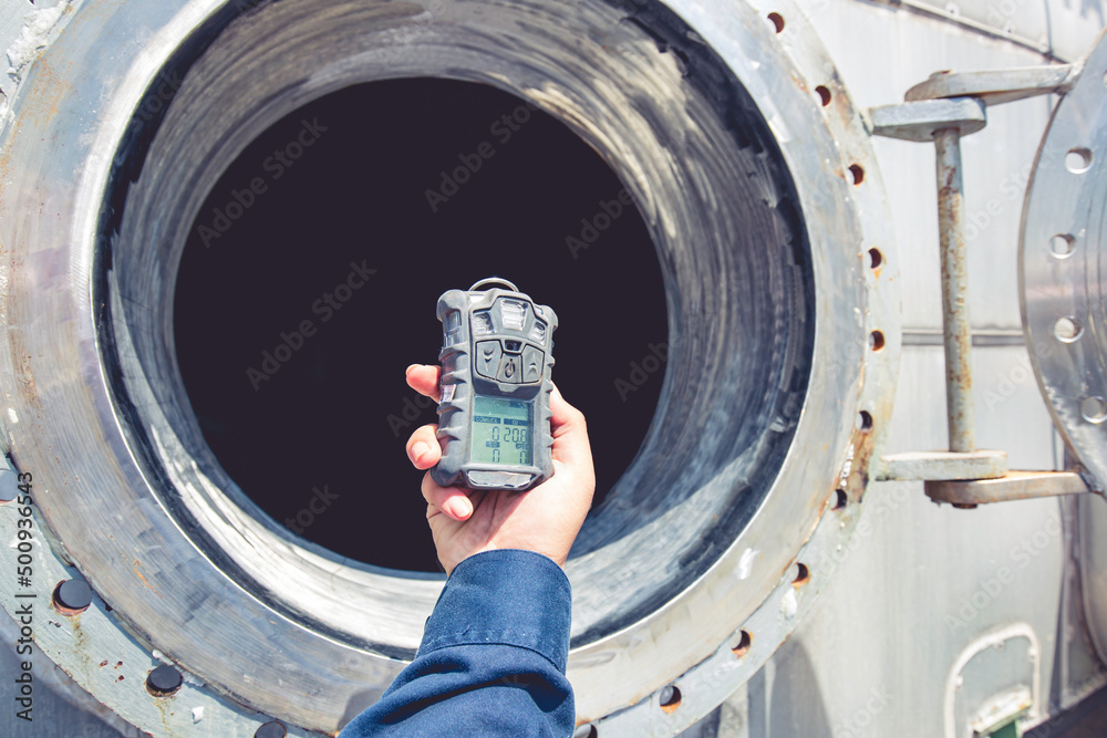 Worker hand holding gas detector inspection safety gas testing at front ...
