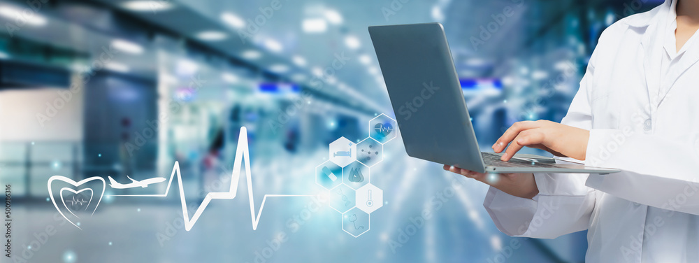 Doctor using laptop computer with hospital background, business ...