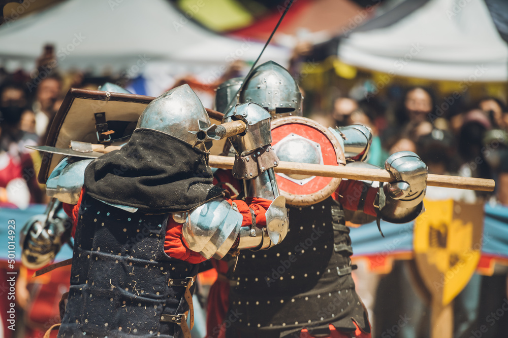 Pitch battle of medieval knights, using metal armor, axes, swords and ...