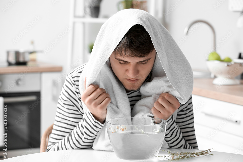 Young man doing steam inhalation at home to soothe and open nasal ...