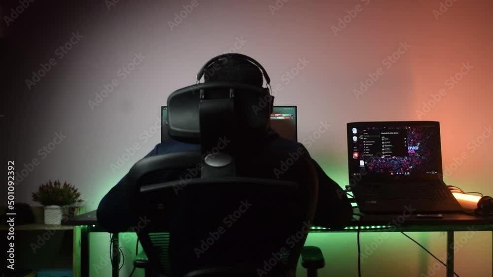 Gamer playing video games on his computer. RGB gaming room setup. vídeo ...