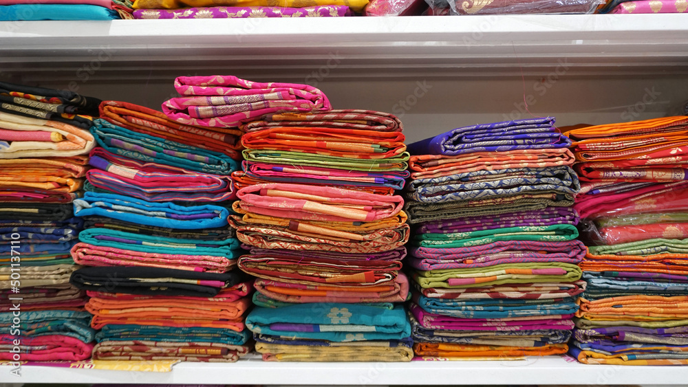 Colorful sarees or saris are arrange on racks and display in a retail ...