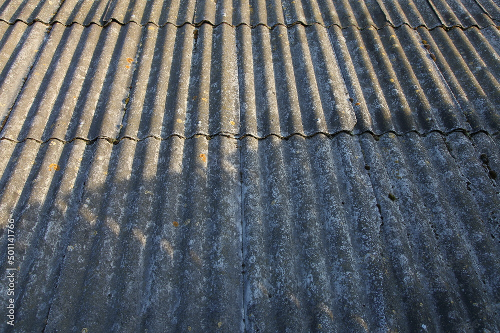 Old asbestos roofing sheets on the roof. Corrugated panels, grey slate ...