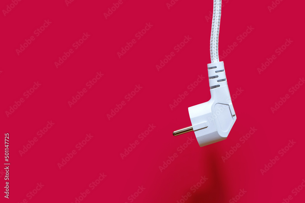Electric plug for a socket on a red background. The concept of ...