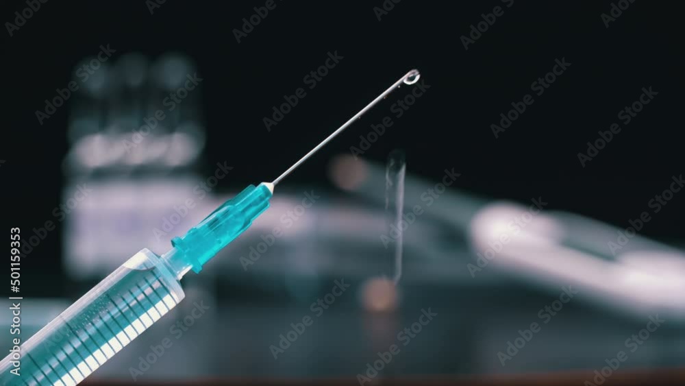 Learstvo is dripping from medical syringe, flowing down in large drops ...